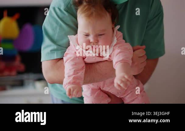 Healthcare professional wearing a medical mask gently supporting a baby ...
