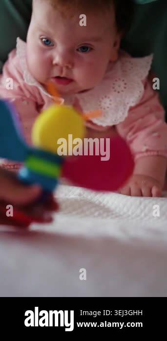 Healthcare professional wearing a medical mask gently supporting a baby ...