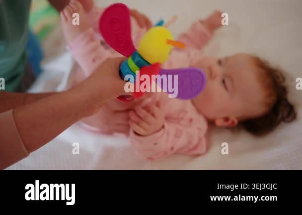 Colorful sensory toy held in front of a baby during a pediatric therapy ...