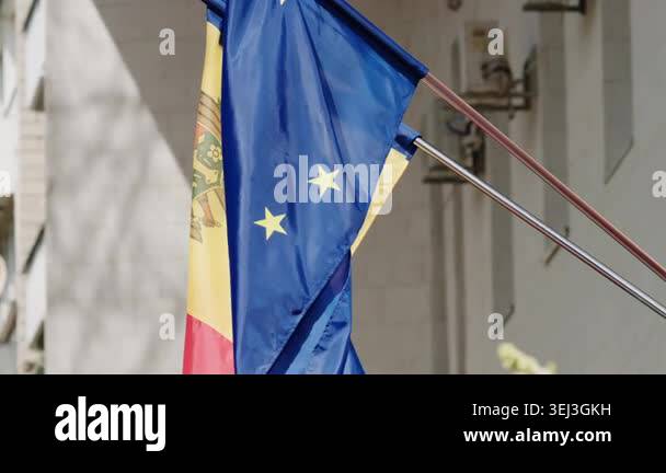 European Union and Moldova flags waving in the wind outside a building ...