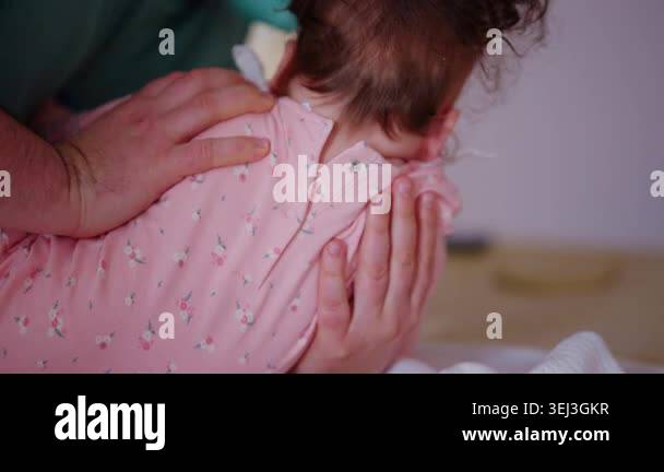 Adult interacting with a baby on a treatment table while holding a ...