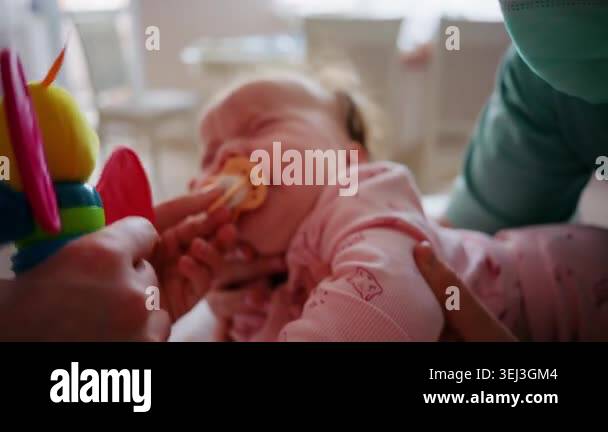 Baby crying while holding an adult's hand during a pediatric therapy ...