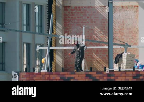 Workers inside a modern building under construction with exposed brick ...