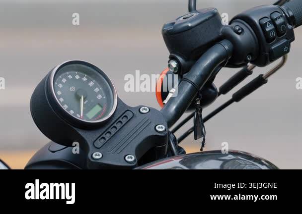 Detailed close up of a black motorcycle handlebar, speedometer, mirror ...