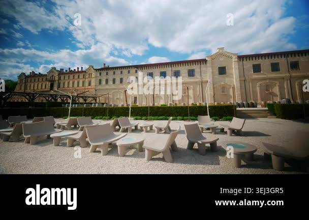 Low angle view of outdoor lounge chairs and tables at winery castle in ...