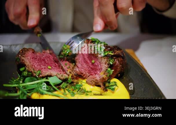 Close up of a medium rare steak being cut open at a restaurant Stock ...