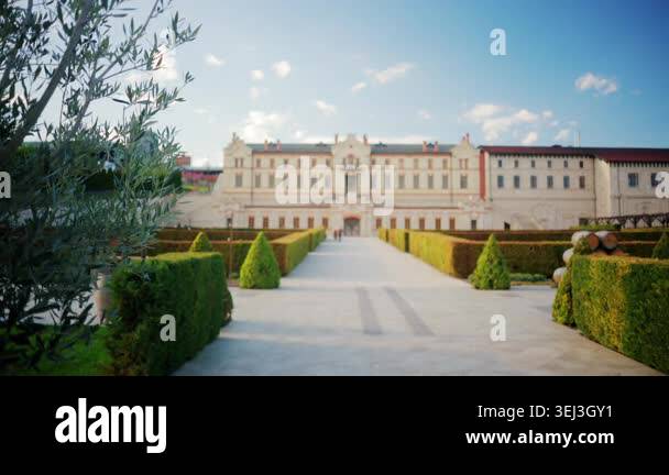 A potted olive tree frames the walkway and historic facade of winery ...