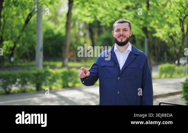 Smiling individual points with assurance in outdoor park setting ...