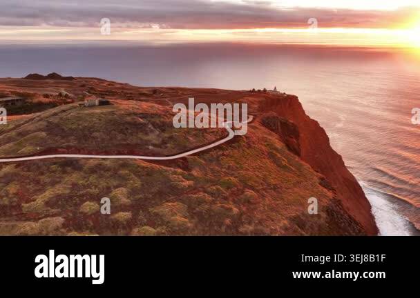 Vibrant sunset bathes Madeira Portugal coastal cliffs and ocean in warm ...
