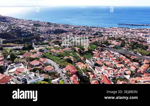 Moving aerial perspective shows a city built on hillsides along the ...