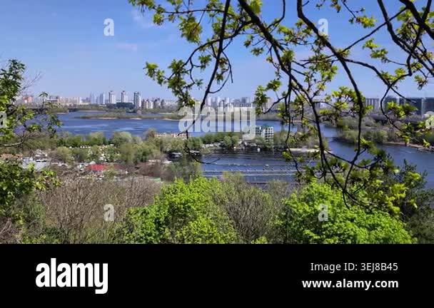 Panoramic city skyline river view through spring trees in Kyiv Ukraine ...