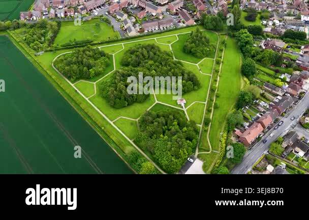 Aerial drone footage of geometric woodland park and crop fields beside ...
