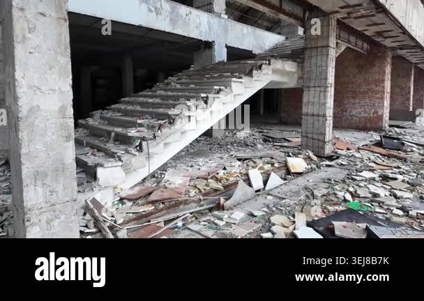 Panoramic shot of a crumbling concrete staircase and debris inside an ...