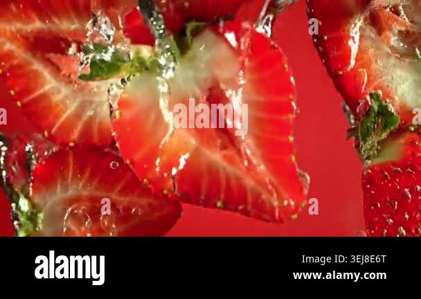 Super Slow Motion Shot of Fresh Strawberries Falling into Water at ...