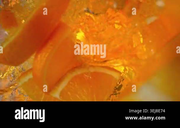 Super Slow Motion Shot of Fresh Orange Slices Falling into Lemonade at ...
