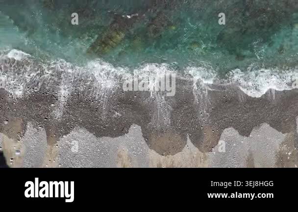 Top down view of the waves at the beach. Right to left side camera ...