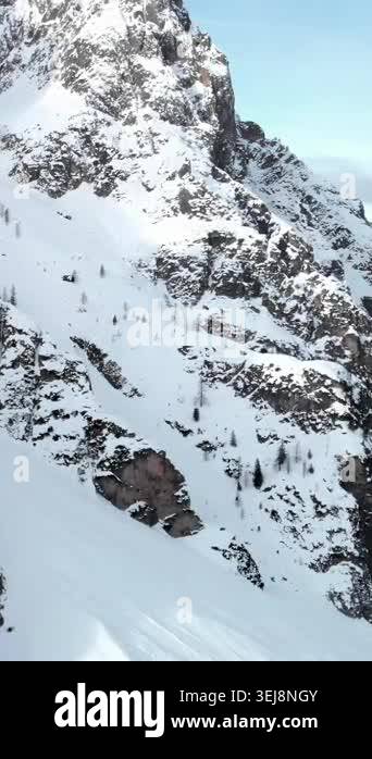 Aerial Drone Over Snow Covered Ridge, Bright Blue Sky And Towering ...