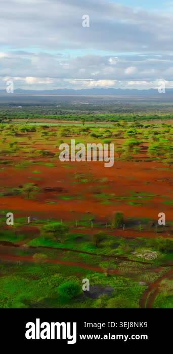 Red Soil Patchwork Fields Under Cloudy Sky With Distant Ridgeline ...