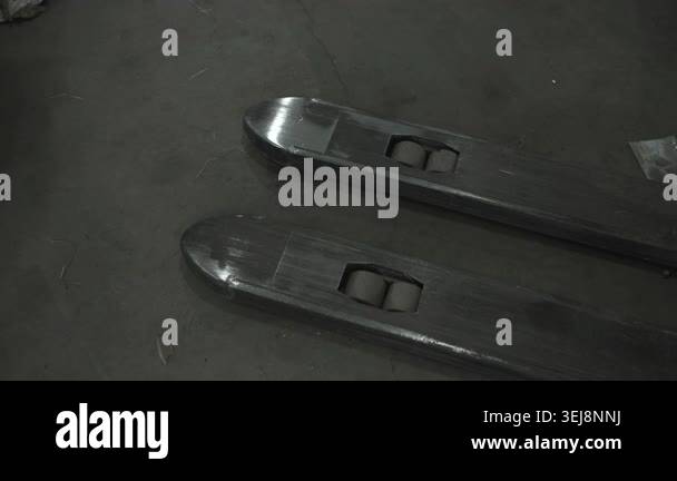 Pallet Jack Forks Closeup On Concrete Floor, Worn Rollers And Metal ...