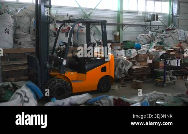 Orange Forklift Parked Inside Cluttered Warehouse Surrounded By Sacks ...