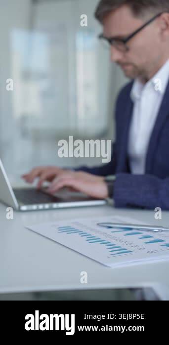Businessman working on a laptop, typing at his desk with focus and ...