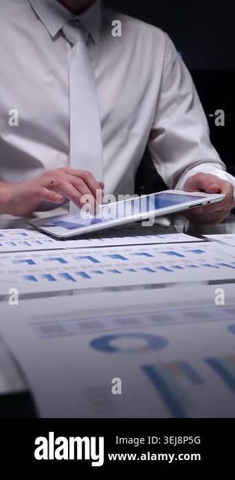 Businessman auditor is checking financial spreadsheets with tablet pc ...