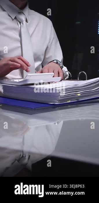 Businessman studying financial report data with calculator and laptop ...