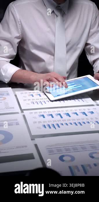Businessman conducting detailed audit checking financial spreadsheets ...