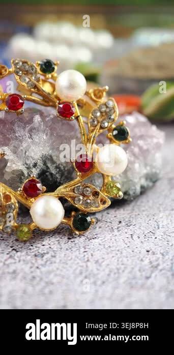 Gold jewelry is placed on colorful stones in this close-up view Stock ...
