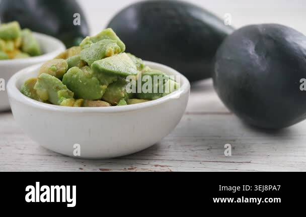 People prepare a salad with fresh avocados and vegetables at a market ...