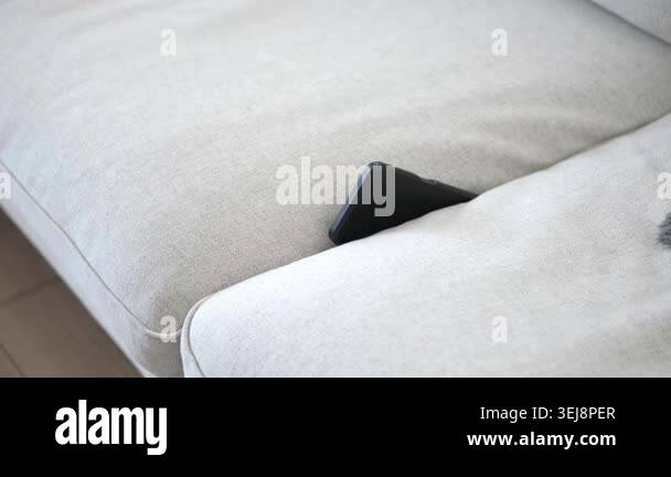 A person looks for a phone lost in a couch while sitting down Stock ...