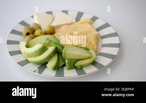A person enjoys eggs, cheese, and fresh fruits on a plate Stock Video ...