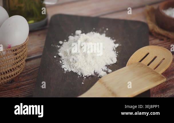 Mixing flour with eggs on a wooden surface in a cozy kitchen Stock ...