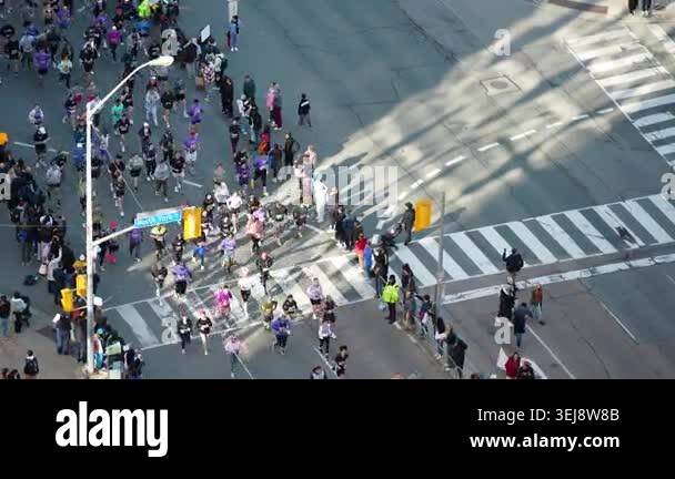 Aerial cinematic footage of runners crossing a major intersection ...