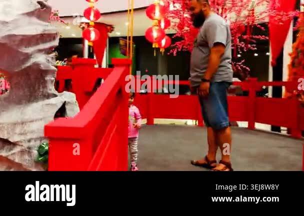 Bearded man standing by red railing with child in pink shirt in ...