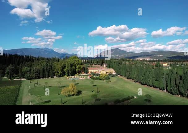 Aerial resort villa beside fairway, sunlit pool and manicured lawn ...