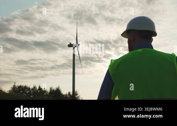 Bearded white inspector walking toward turbines, neon vest glinting ...