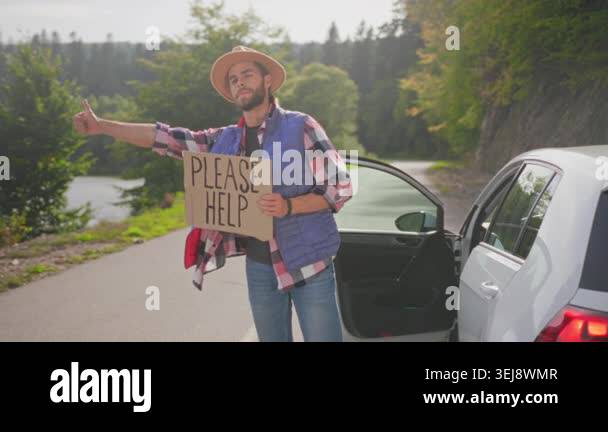 white traveler holds cardboard please help. anxious white man standing ...