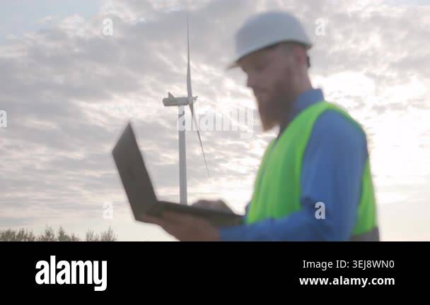 Bearded white engineer calibrating turbine sensors, closeup laptop ...