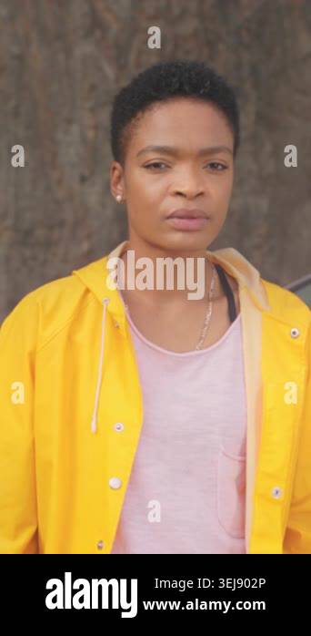 pensive black woman in yellow jacket urban closeup with neutral ...