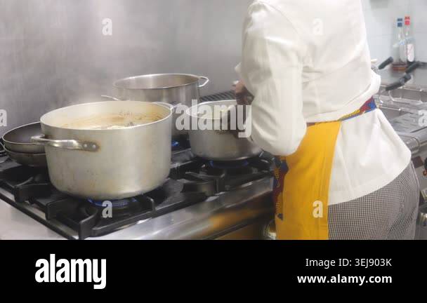 A skilled chef is actively cooking authentic African dishes in a ...