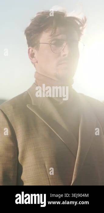 Backlit white man standing outdoors during golden hour, wearing ...