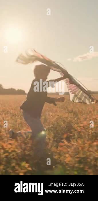 boy running in golden field at sunset, colorful scarf billows like ...