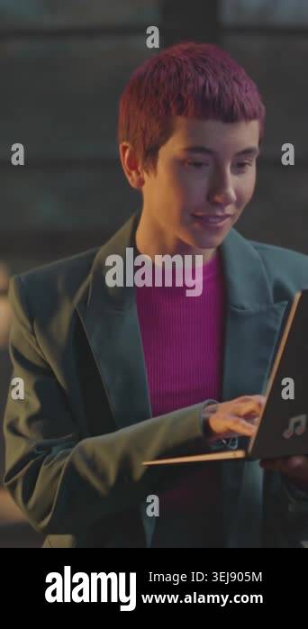 studio freelancer typing on laptop stickered cover warm window light ...