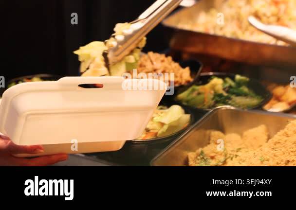 Street food being packed into takeaway plastic container for office ...
