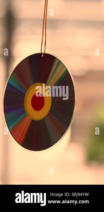 Hanging CD disc decoration reflecting rainbow colors in wind closeup ...