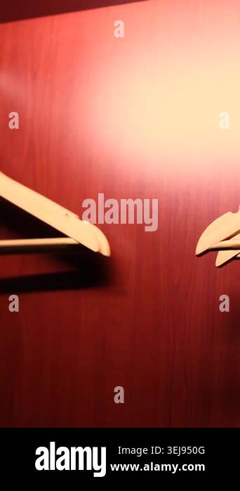 Warm lit empty hangers inside wardrobe hotel room interior closeup ...