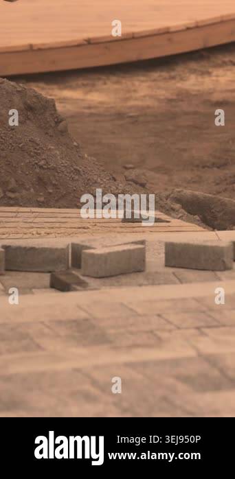 Urban street construction cutting stone and laying pavement bricks ...
