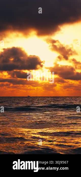 Golden sunrise over sea horizon with scenic cloudscape vertical ...