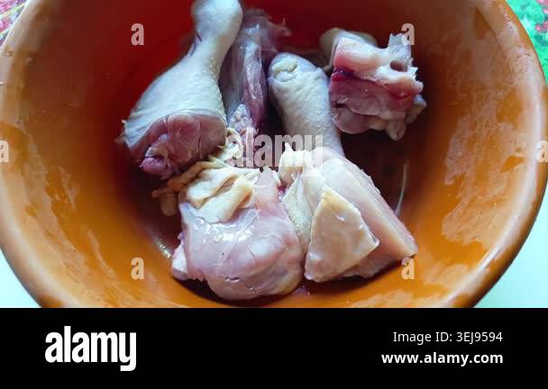 Several fresh pieces of raw chicken, including drumsticks and thighs ...
